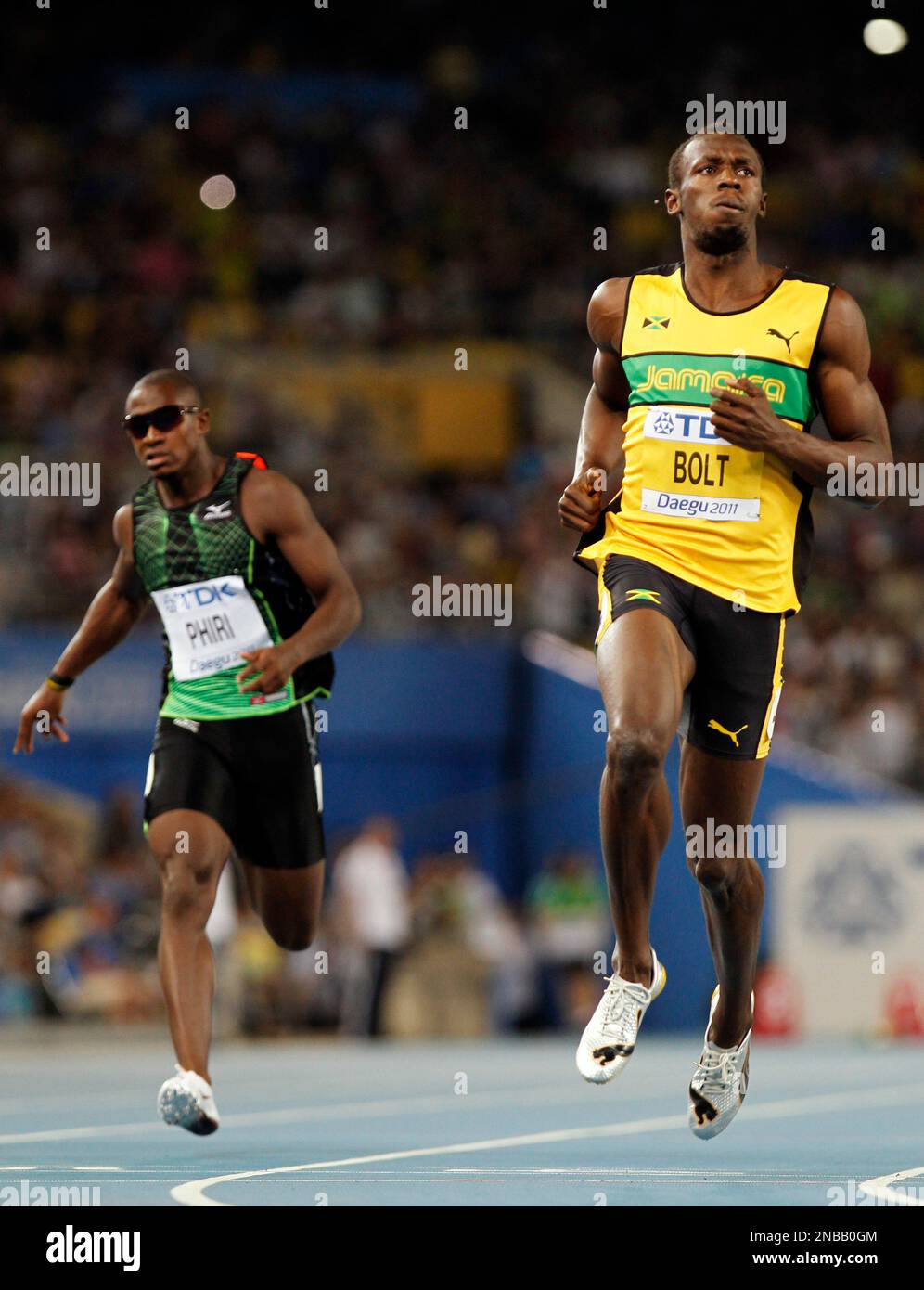 Jamaica's Usain Bolt, right, crosses the finish line ahead of Zambia's ...