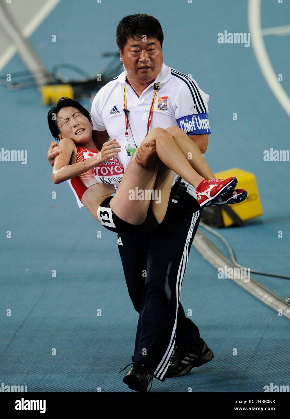 Japan's Megumi Kinukawa is carried off the track by an umpire following ...