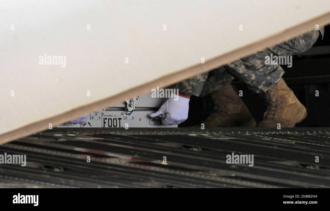 The gloved hand of Army carry team member lifts a transfer case ...