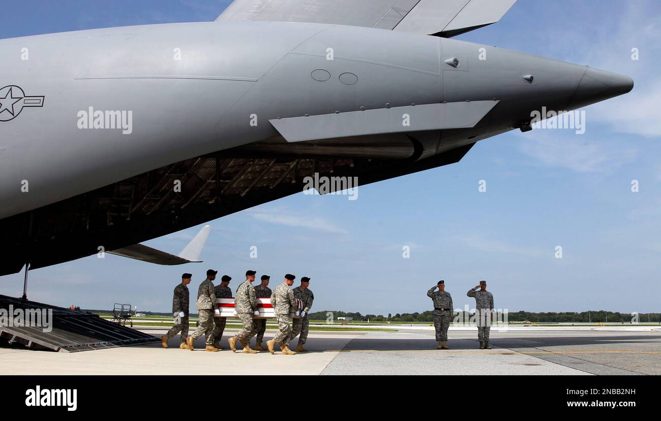 An Army carry team lifts a transfer case containing the remains of Army ...