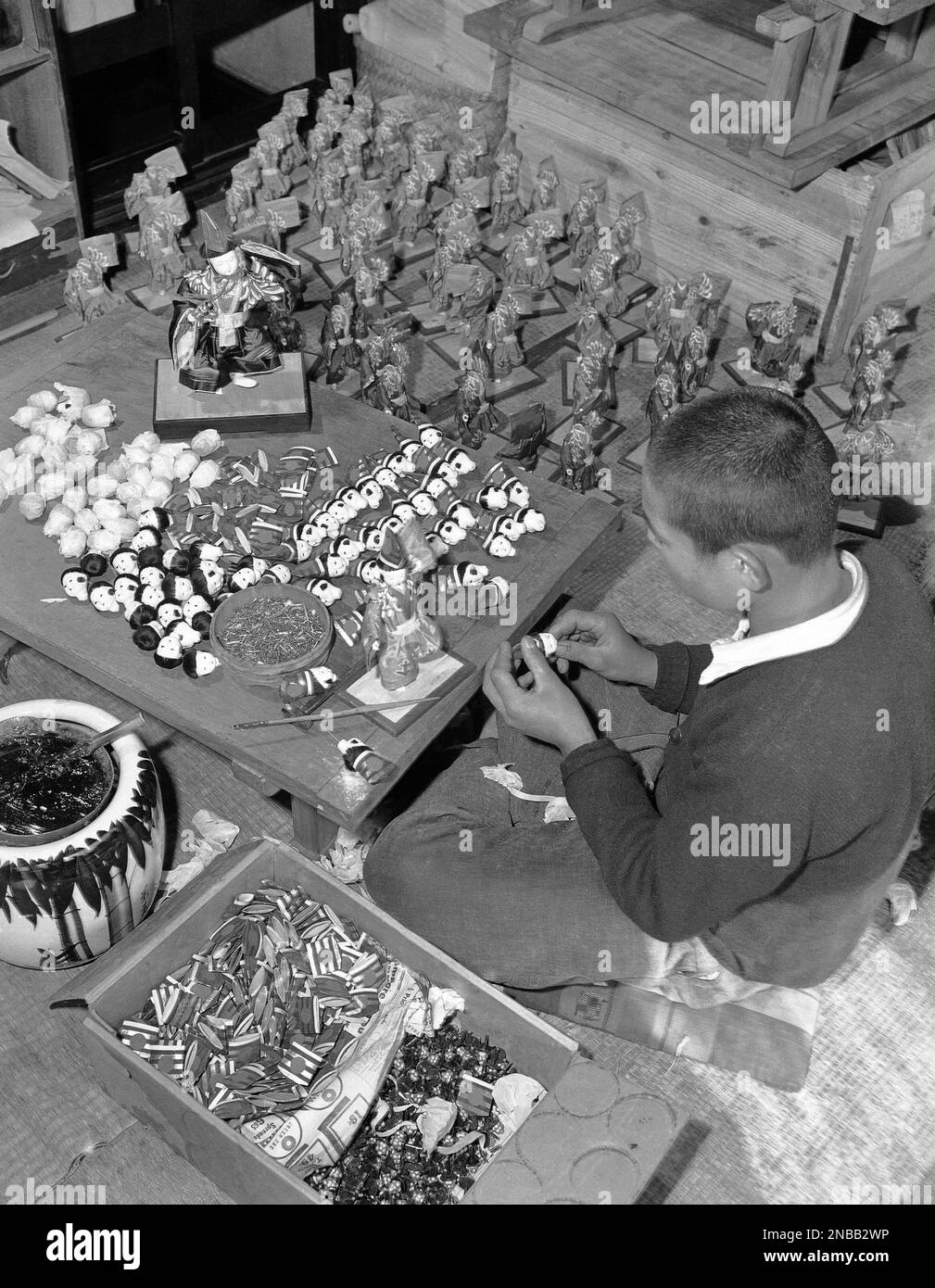 A young boy paints faces for dolls in Tokyo on Jan. 26, 1950, which ...