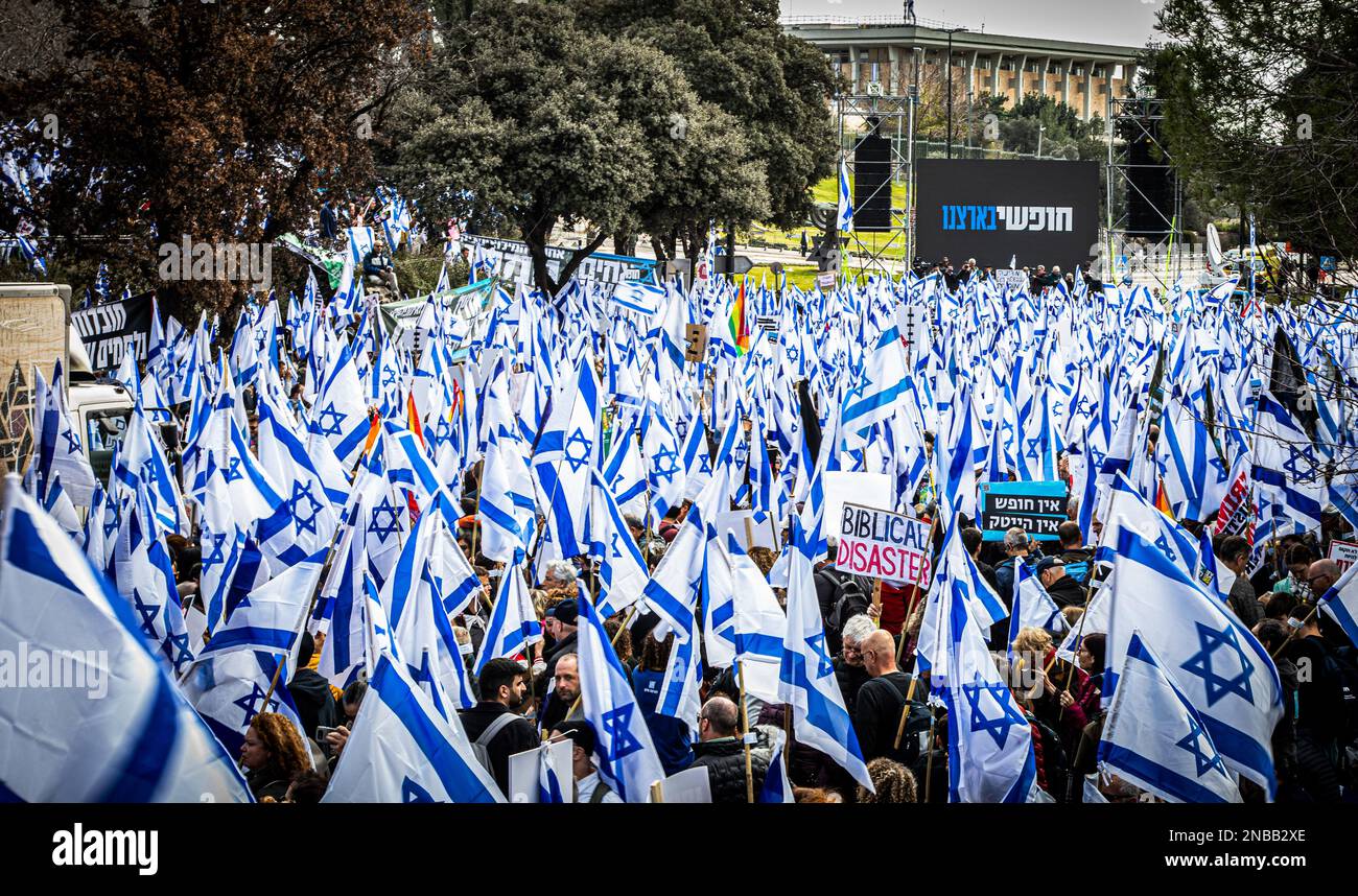Protestors wave flags and hold placards during the demonstration. Tens ...