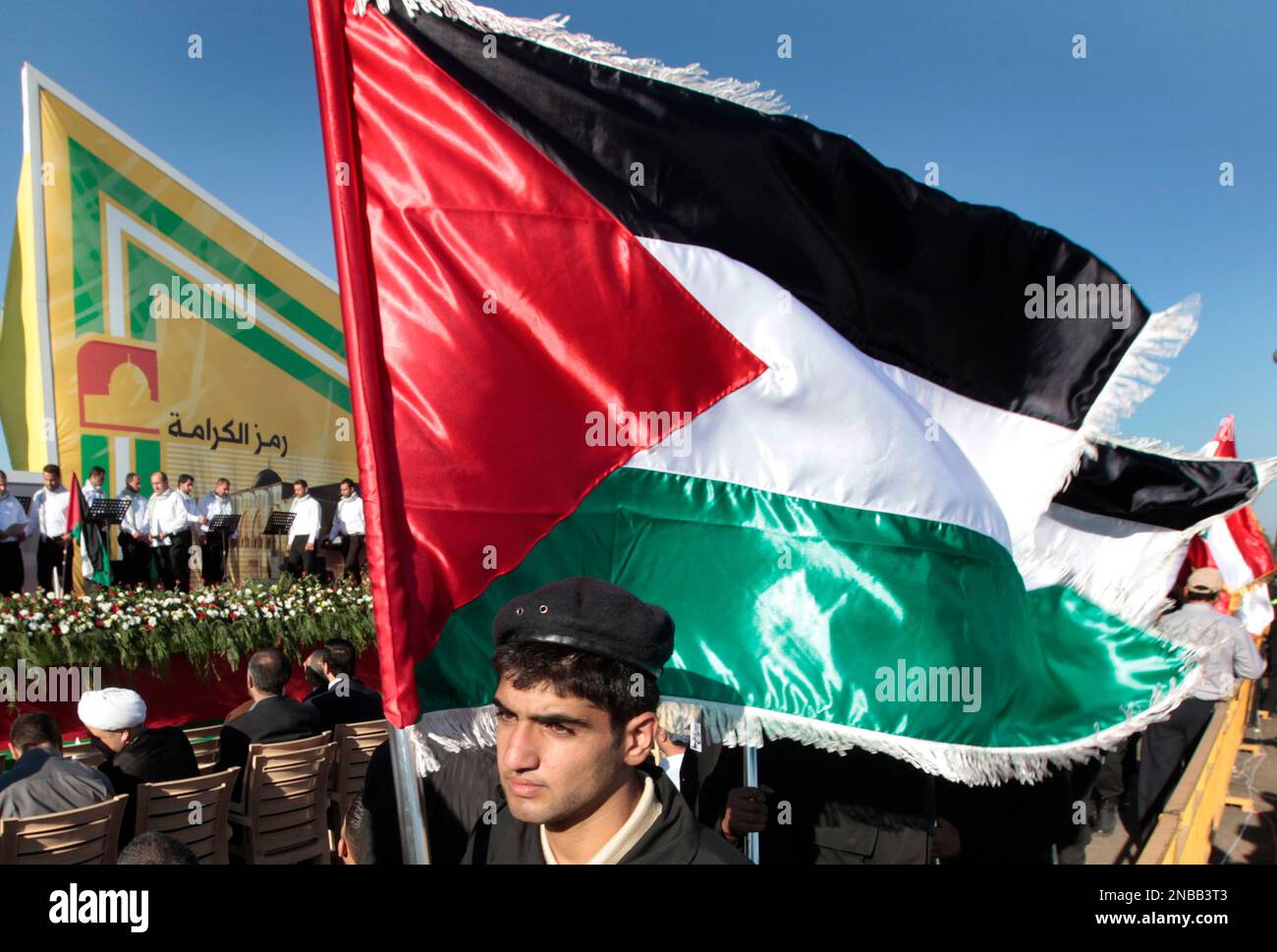 A Hezbollah fighter holds a Palestinian flag during a rally to mark "Al ...