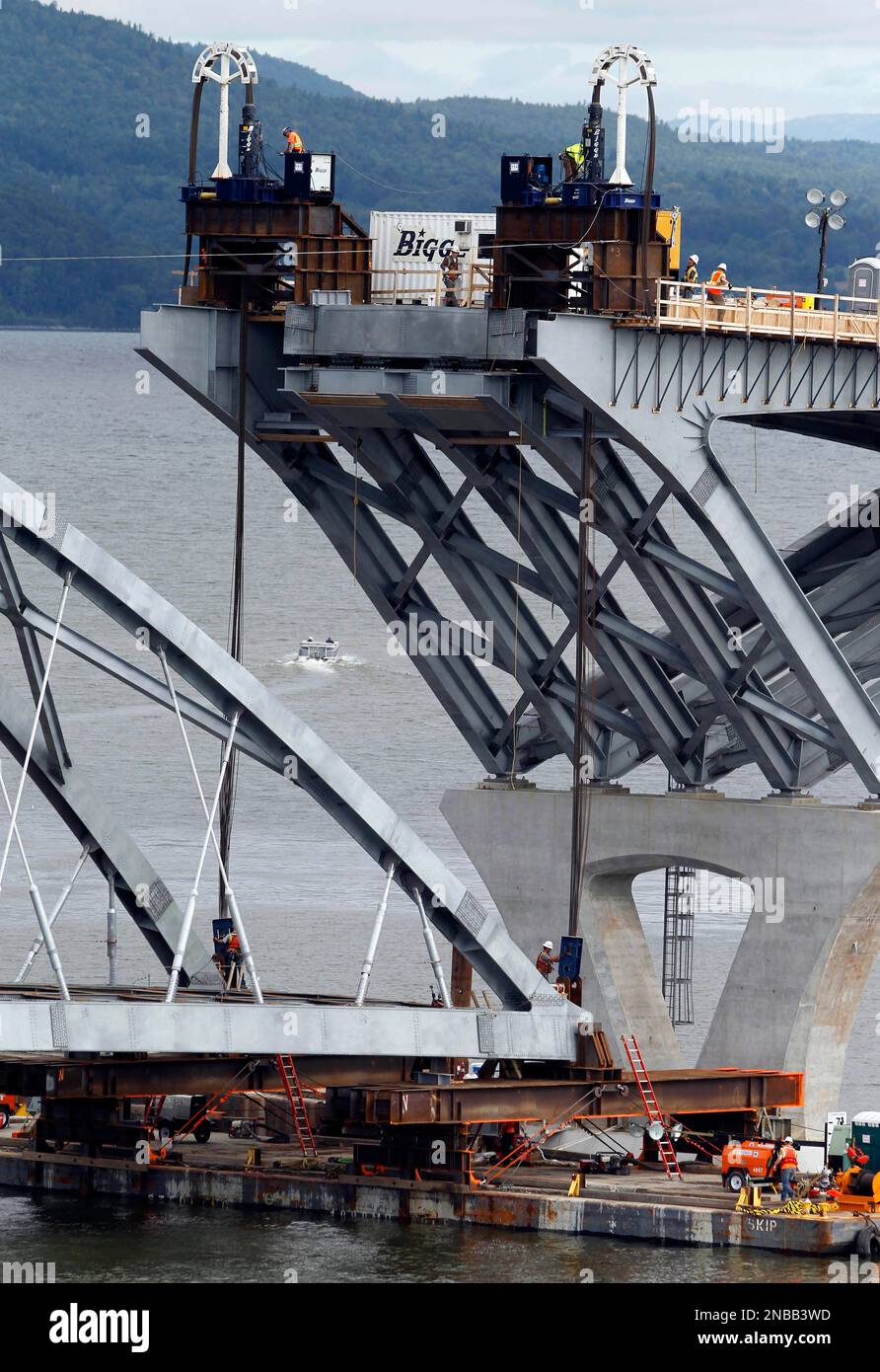 Workers position the center arch span to the Lake Champlain Bridge ...
