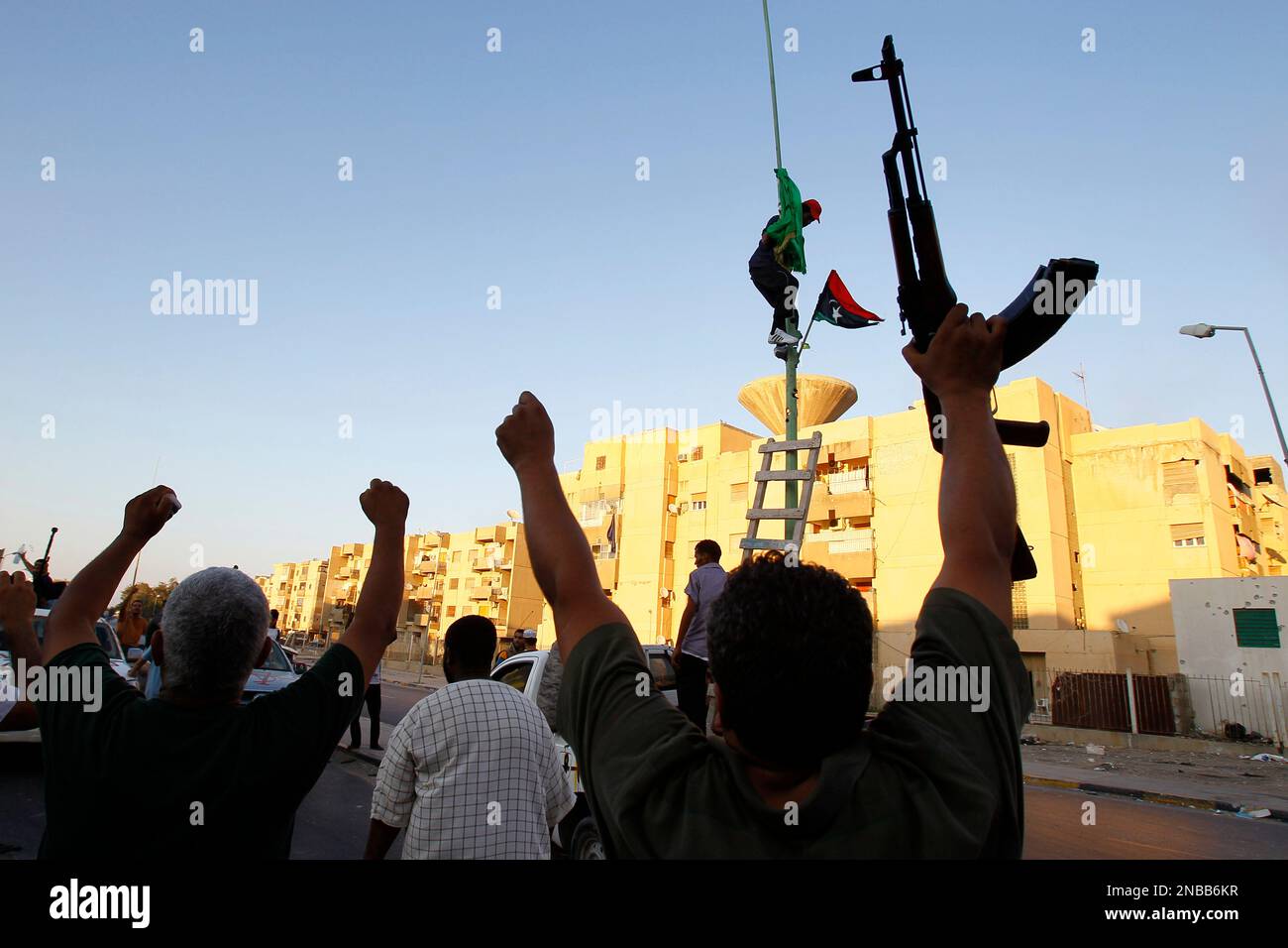 Libyan rebels gesture as they change the flag in Abu Salim district in ...