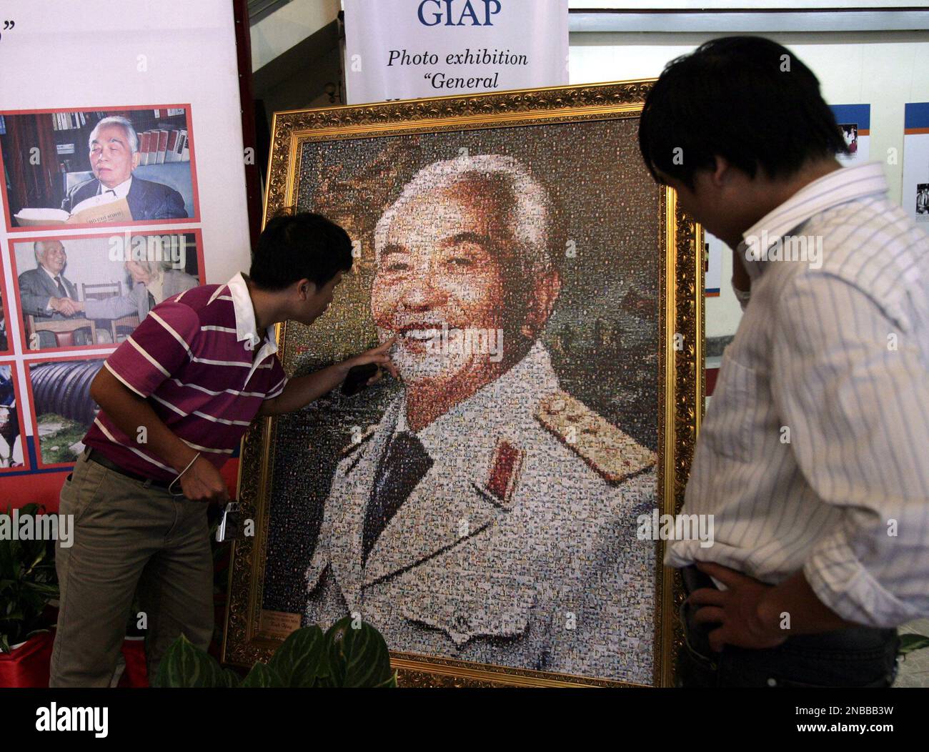 Vietnamese men look at a portrait of Gen. Vo Nguyen Giap at a photo ...
