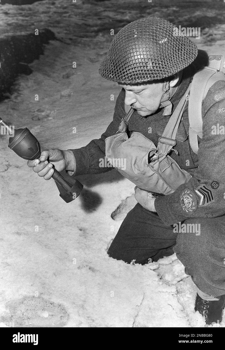 A Canadian Sergeant Major holds one of the bombs used in the new Piat ...
