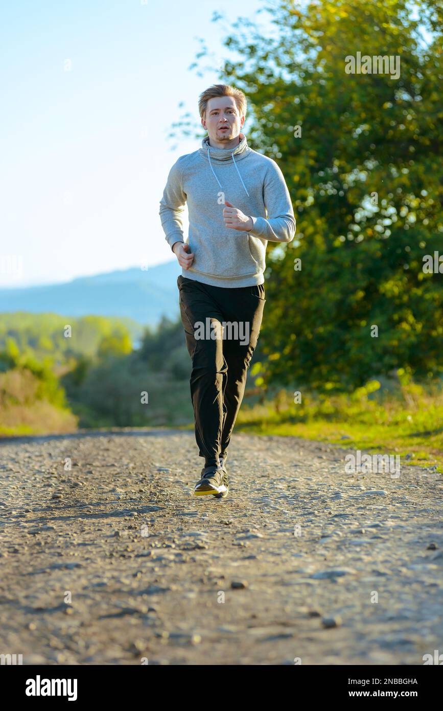 Running man jogging in rural nature at beautiful summer day. Sport ...