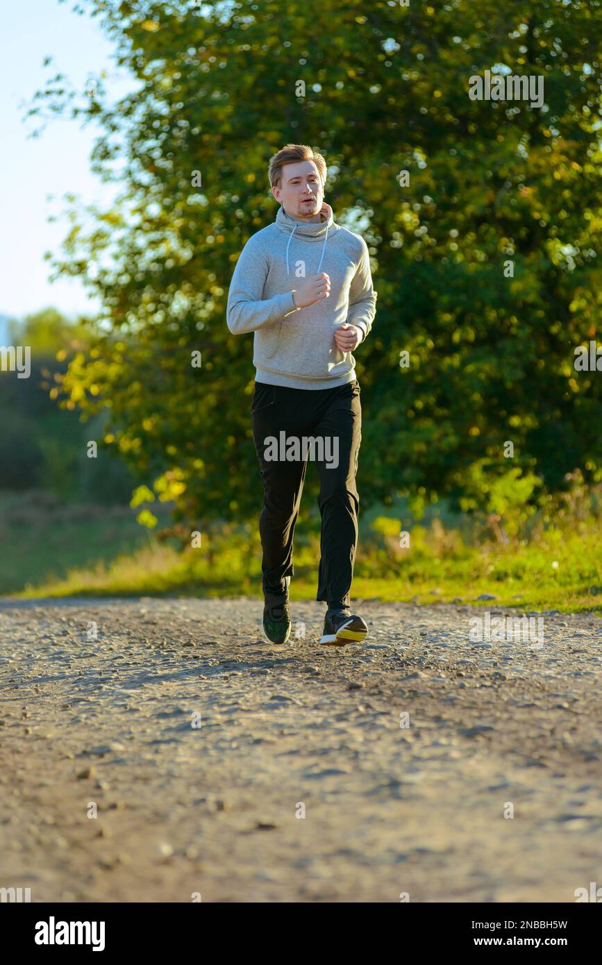 Running man jogging in rural nature at beautiful summer day. Sport ...