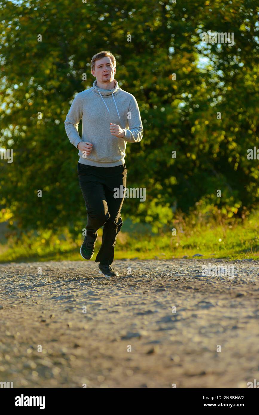 Running man jogging in rural nature at beautiful summer day. Sport ...
