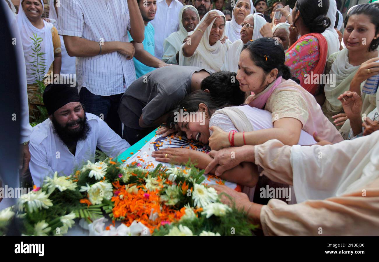 Mother of slain Indian army officer Lt. Navdeep Singh is comforted by a ...