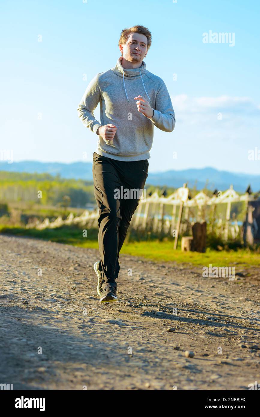 Running man jogging in rural nature at beautiful summer day. Sport ...