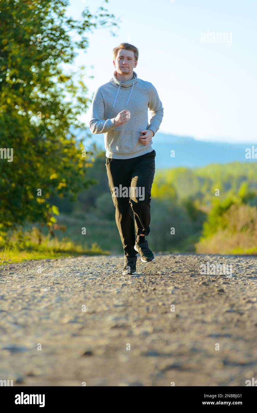 Running man jogging in rural nature at beautiful summer day. Sport ...