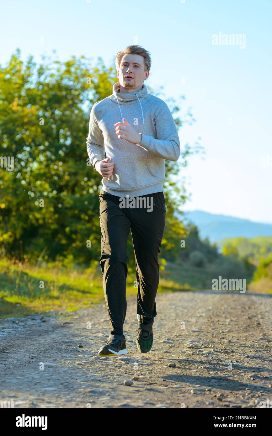 Running man jogging in rural nature at beautiful summer day. Sport ...