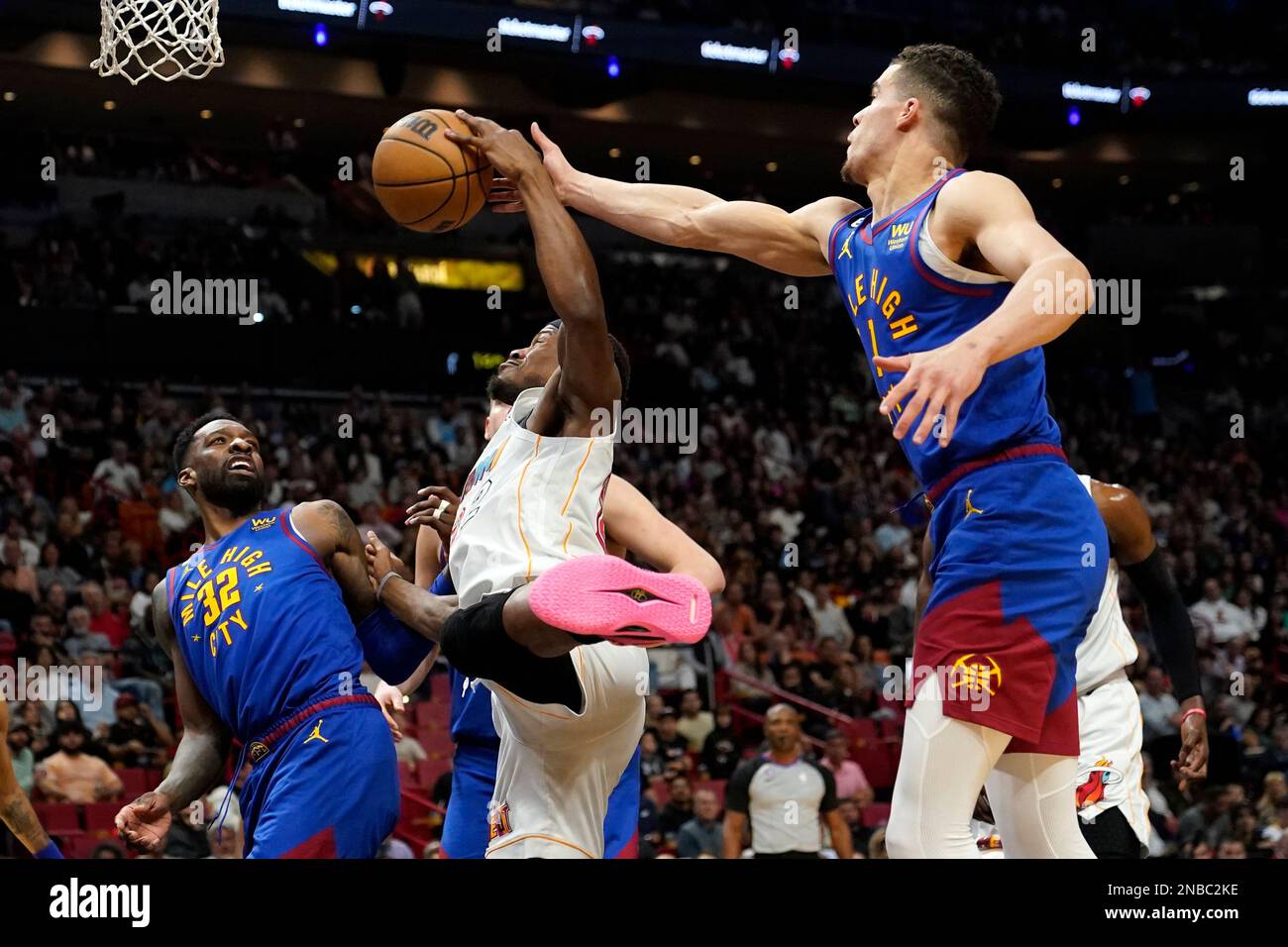 Miami Heat forward Jimmy Butler, center, goes to the basket as Denver ...