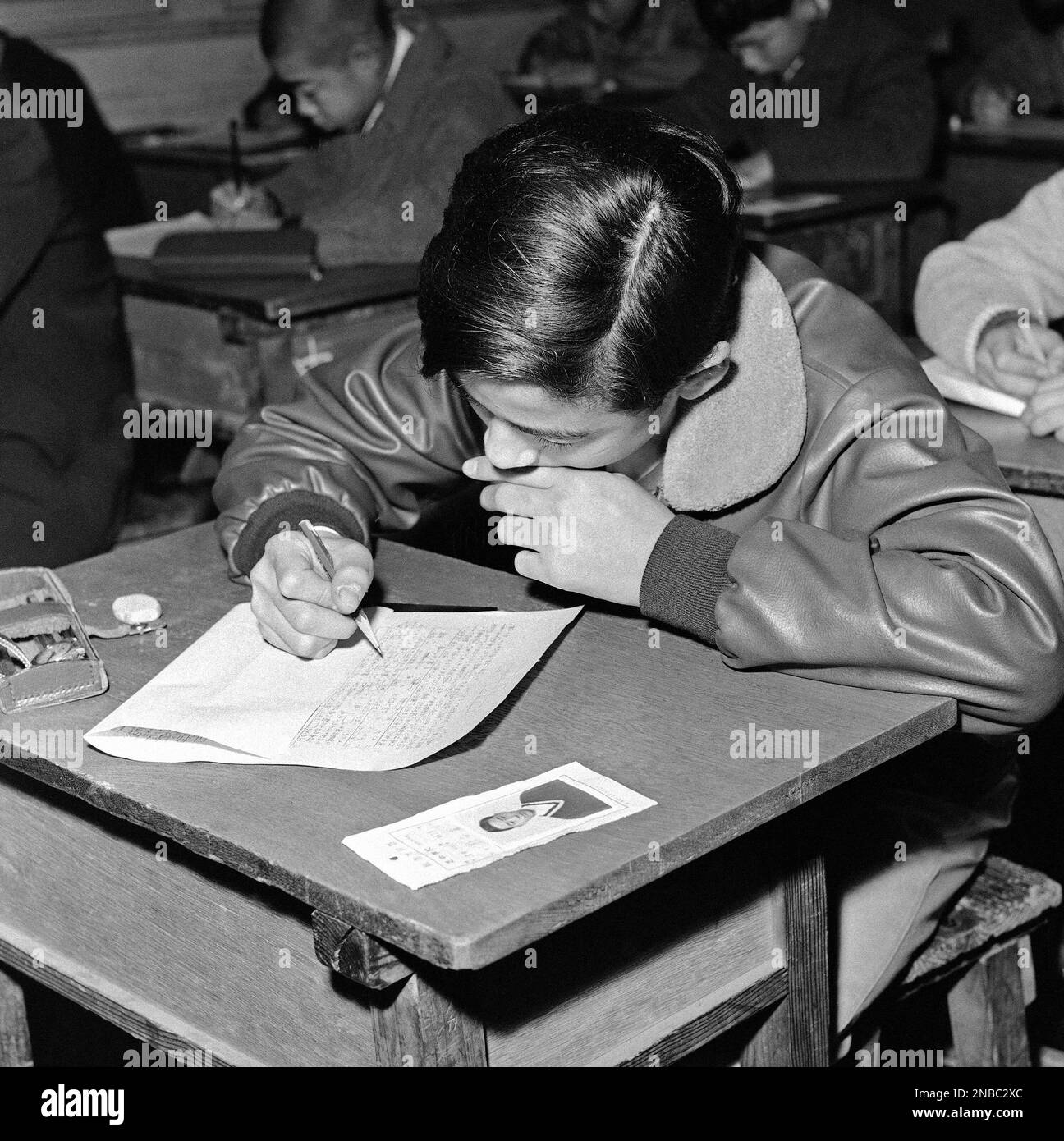 A sixth grader bends over his desk and concentrates on one of the most ...