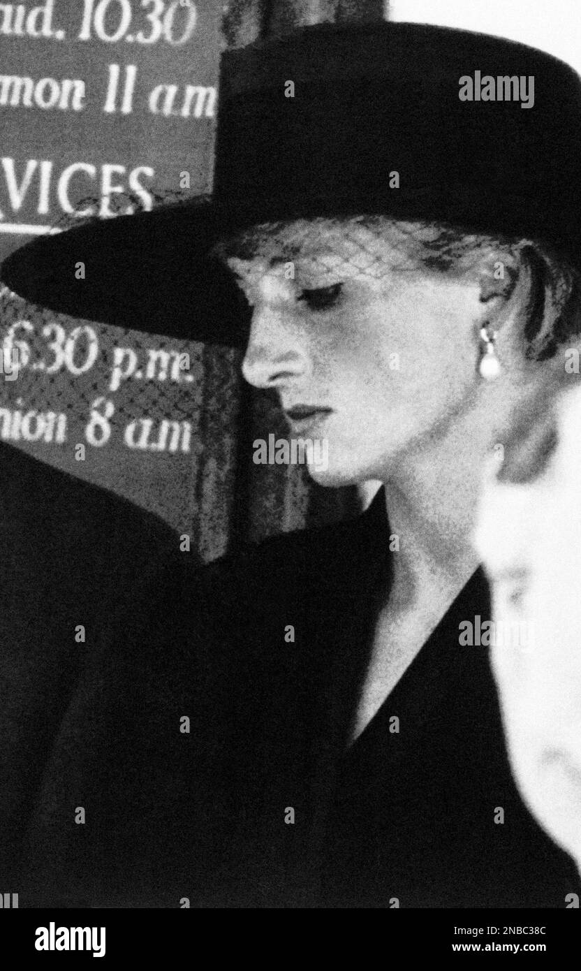 A somber-looking Princess of Wales, Princess Diana, wearing a wide ...