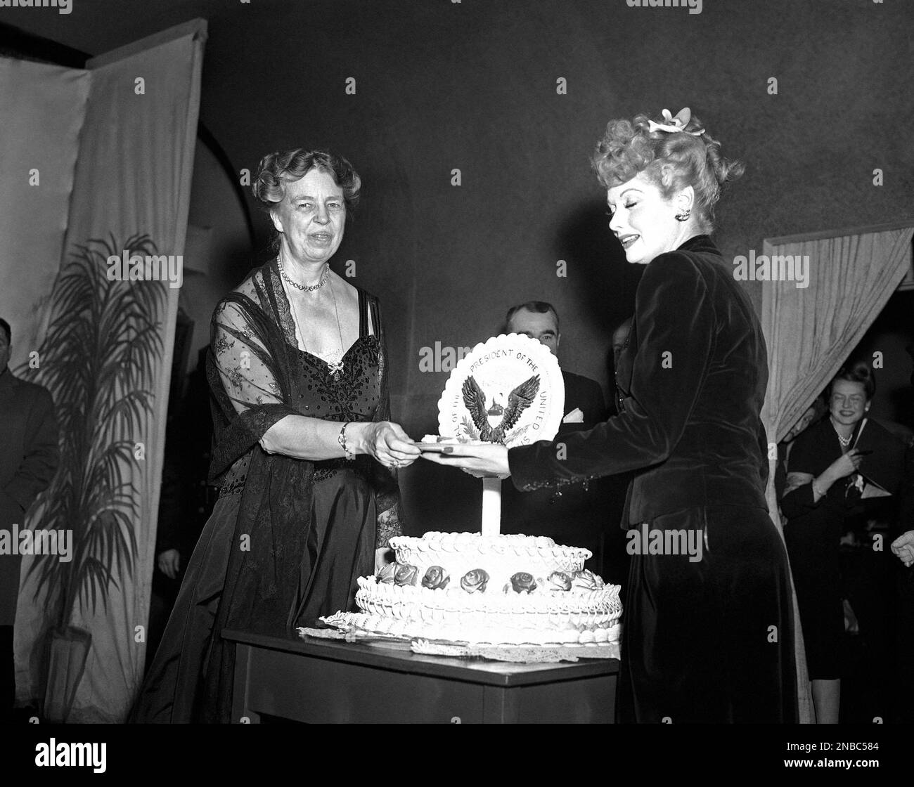 Assisted by film actress Lucille Ball, right, first lady Eleanor ...