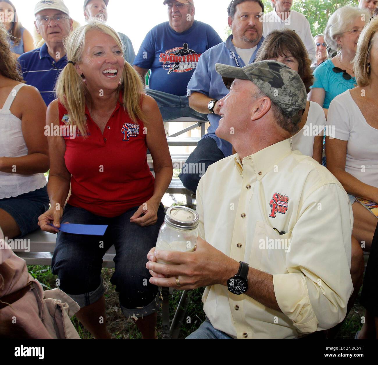 First lady Cheri Daniels hands a jar of milk to Indiana Gov. Mitch ...