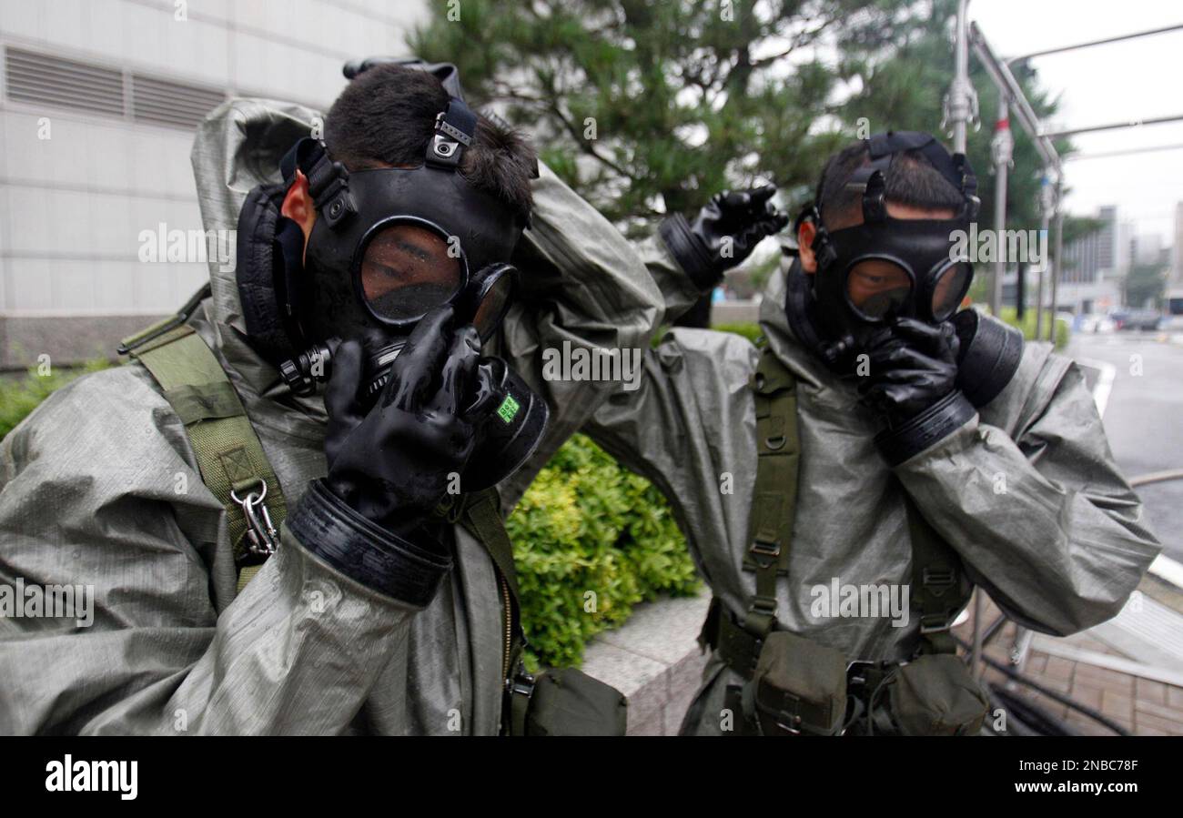 South Korean army soldiers put on gas masks against a smoke attack ...