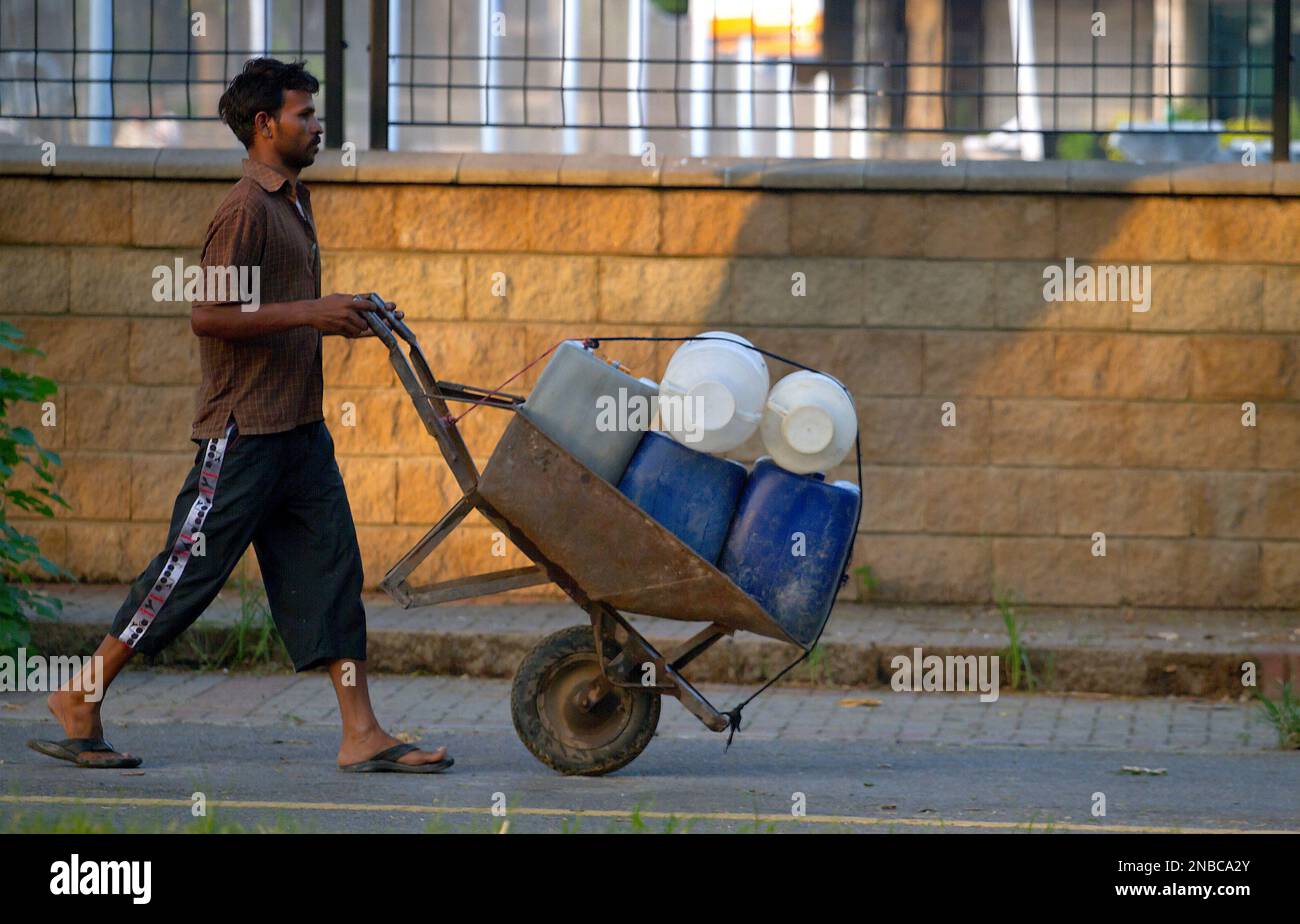 A Pakistani drives wheelbarrow loaded with water-containers to get ...