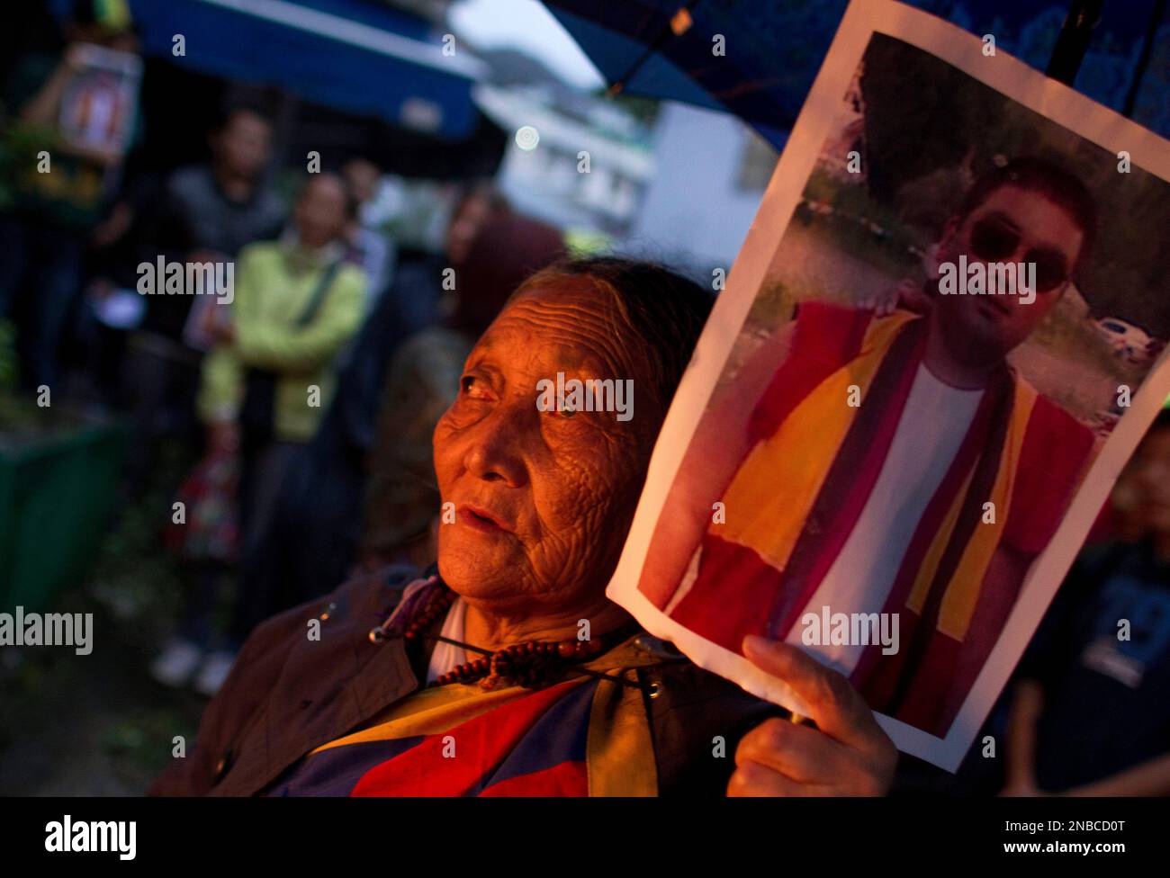 An exile Tibetan holds a portrait of Tsewang Norbu, 29, a Buddhist monk ...