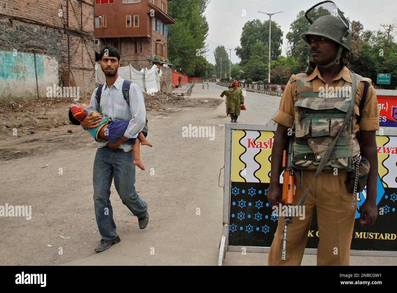 An Indian paramilitary soldier stands guard at a checkpoint as a ...