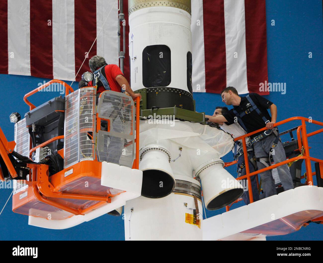 Engineers Chet Graham, left, and Tom Byers, right, attach a collar to ...