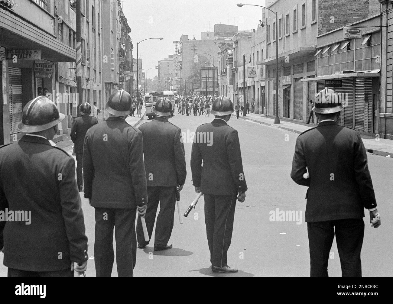 Helmeted policemen face a group of rock-throwing students during ...