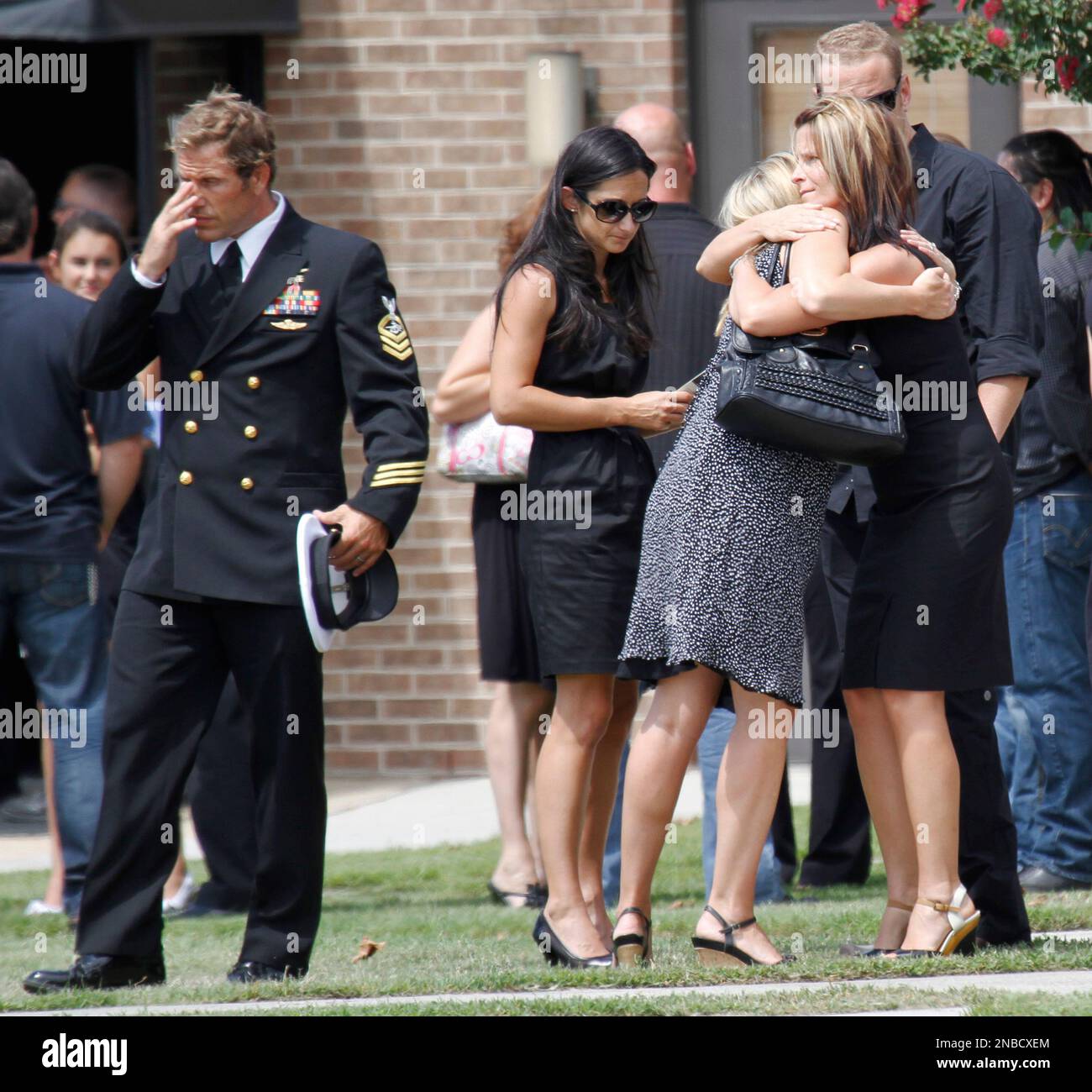 Mourners hug after a memorial service for Navy SEAL Kevin Houston at ...