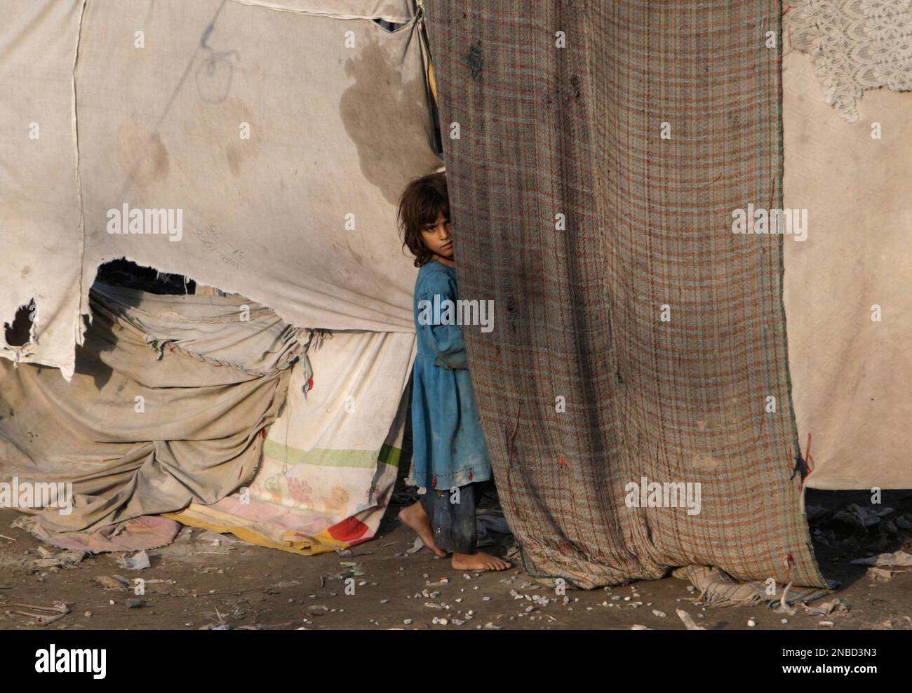 A Pakistani girl who lives in Lahore's slums stands outside her make ...