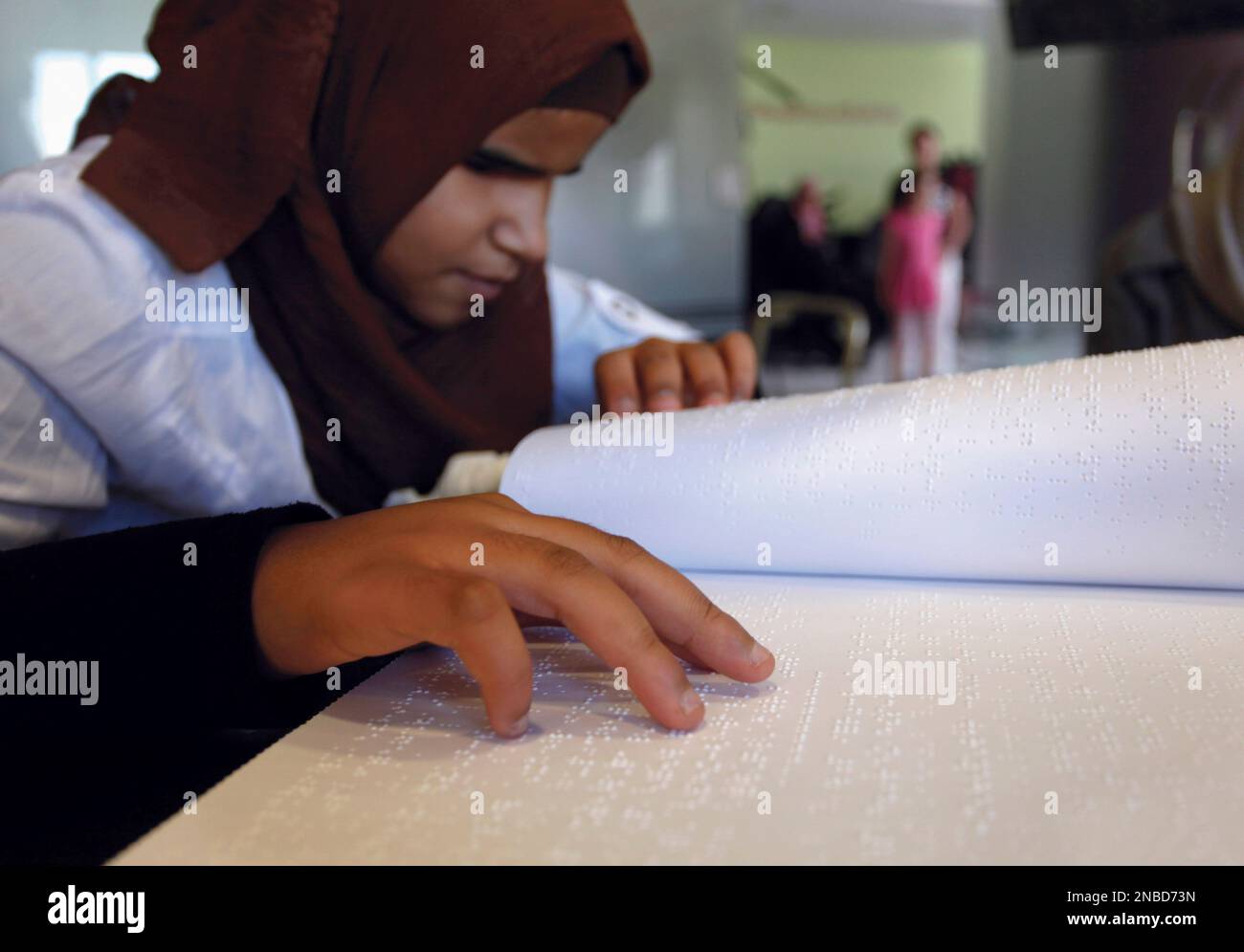 A blind Jordanian youth reads a Quran in Braille, on the ninth day of ...