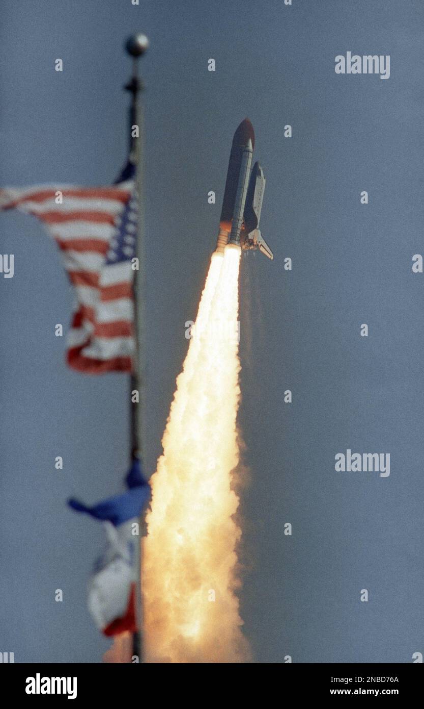 The Space Shuttle Endeavour lifts off behind an American flag at ...