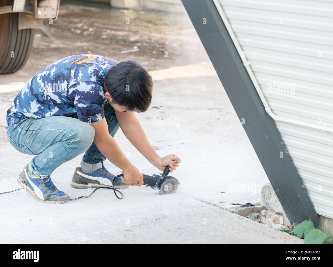 Worker use stone grinding machine cut road floor for tube embeded Stock ...