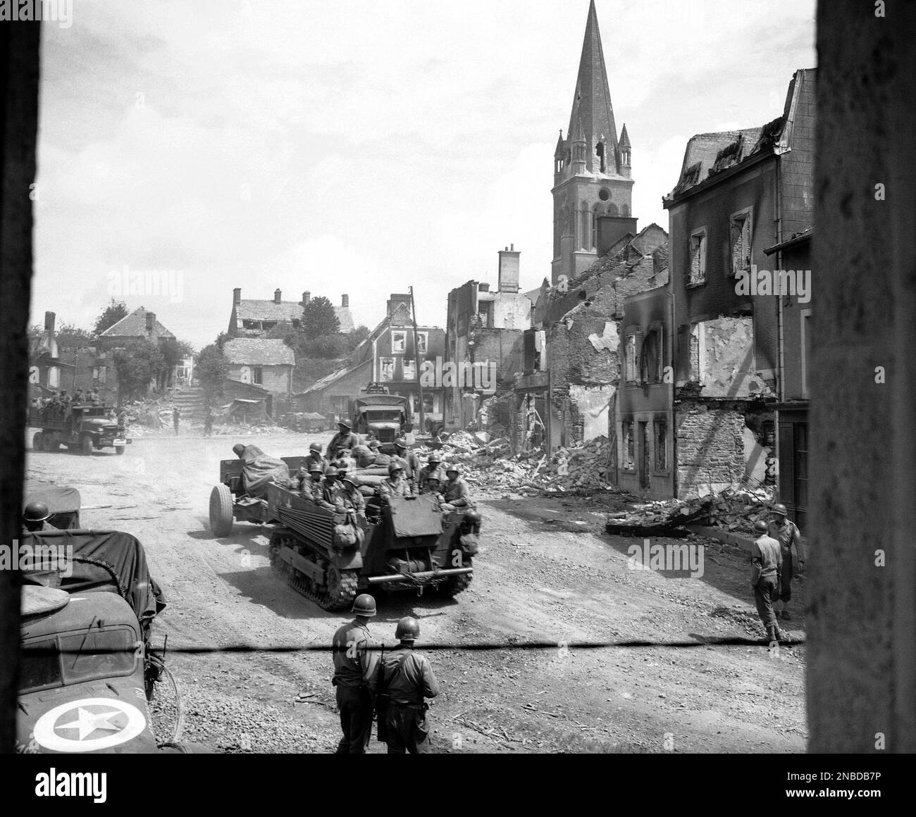 American Troops And Equipment Pass Through A War torn Street In Marigny american-troops-and-equipment-pass-through-a-war-torn-street-in-marigny