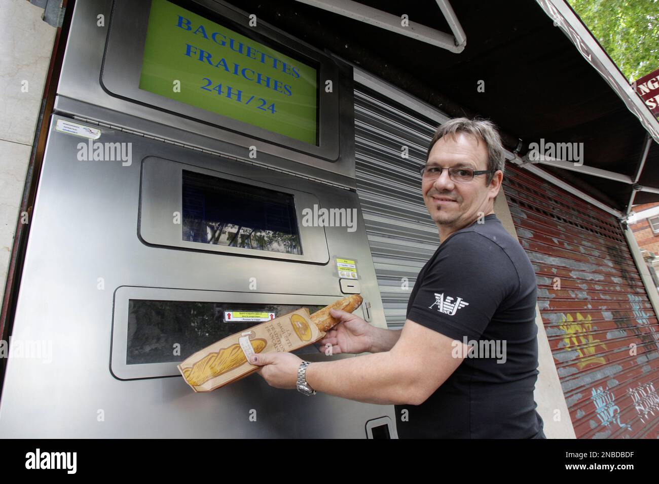 French baker Jean-Louis Hecht stands next to his baguette dispenser as ...