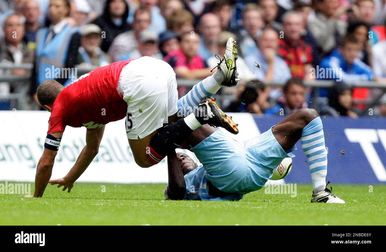 Manchester United's Nemanja Vidic, left, collides with Manchester City ...