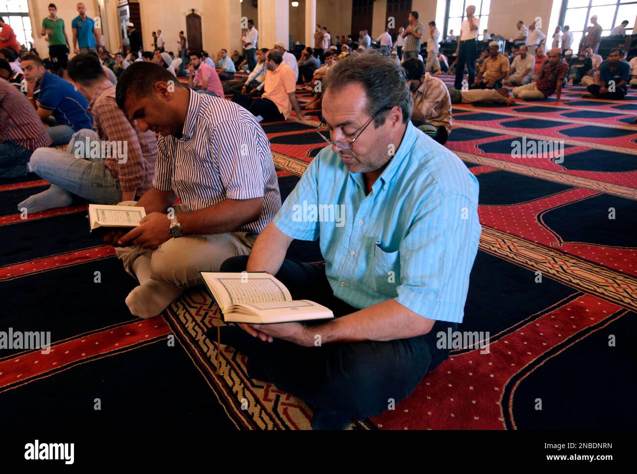 Lebanese Muslims read in the Quran before Friday prayers at Mohammed Al ...