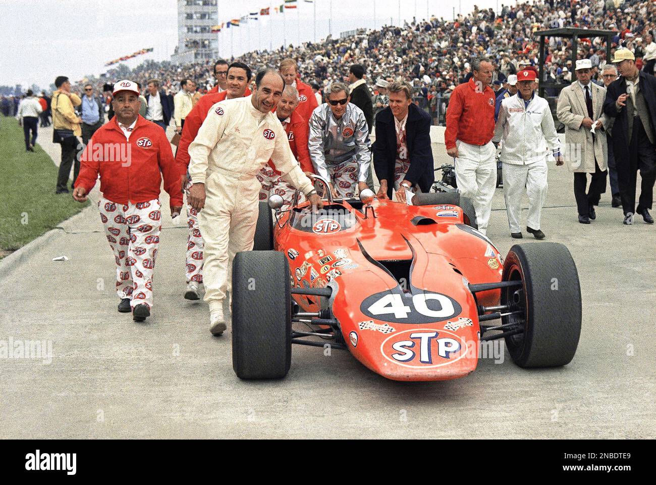 Crew members push the STP-Paxton turbine-powered car of Parnelli Jones ...