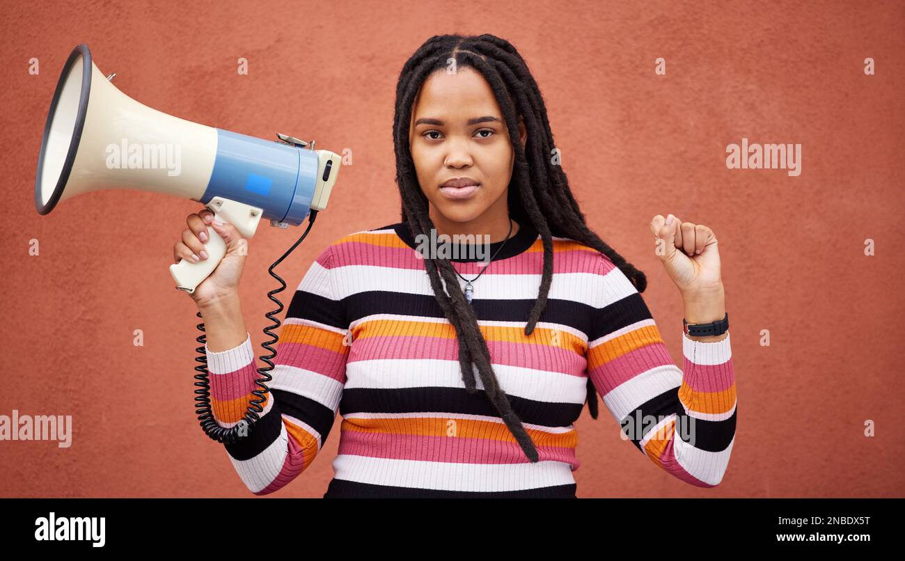 Protest, megaphone and portrait of a woman by a wall in the city for ...