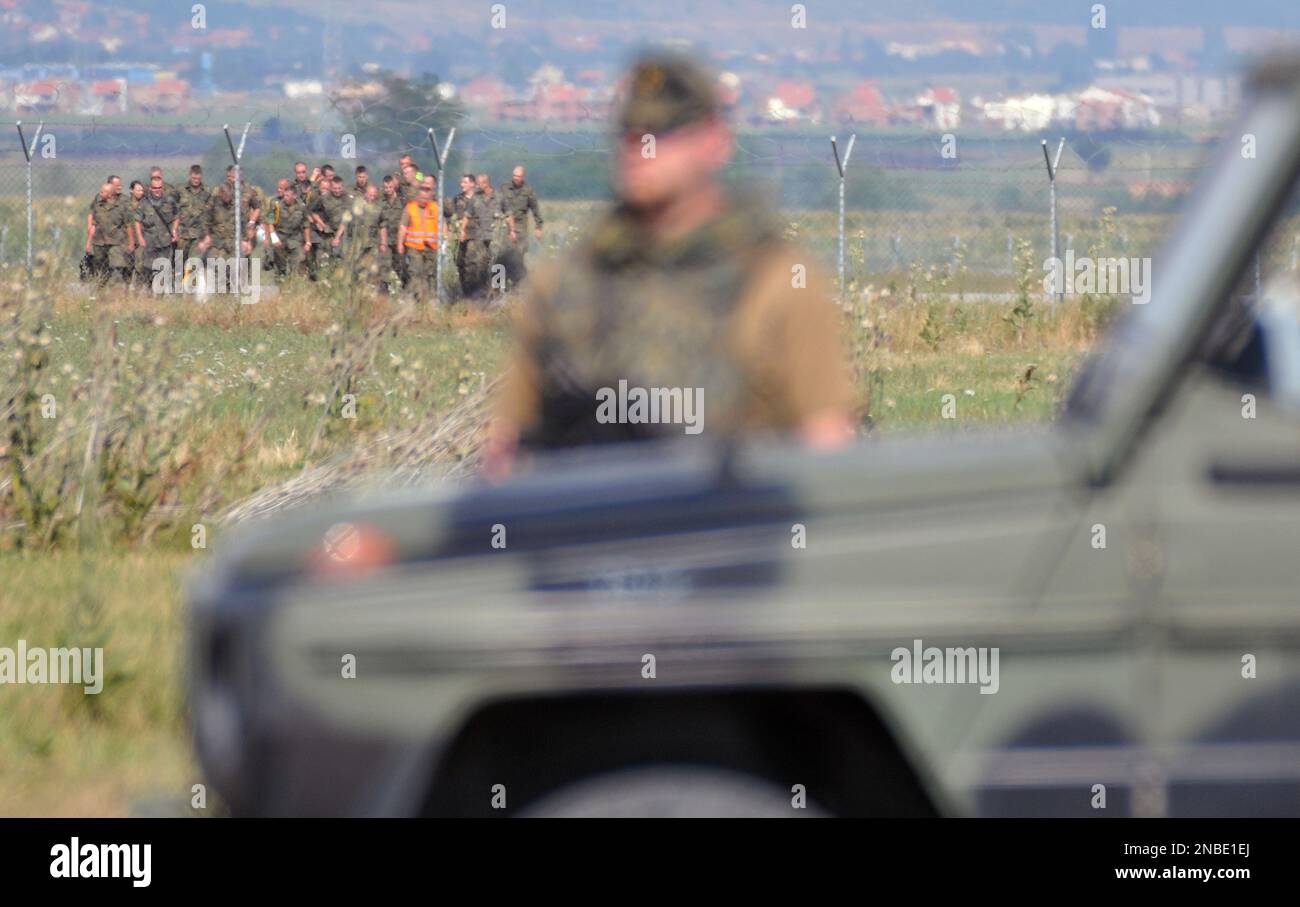 German soldiers secure the area as NATO peacekeepers arrive by plane at ...