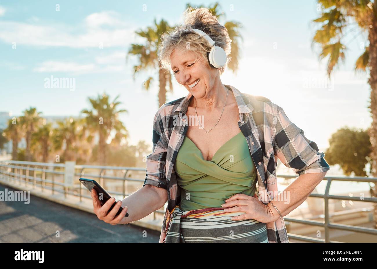 Happy, music and phone with old woman at beach for streaming, freedom ...