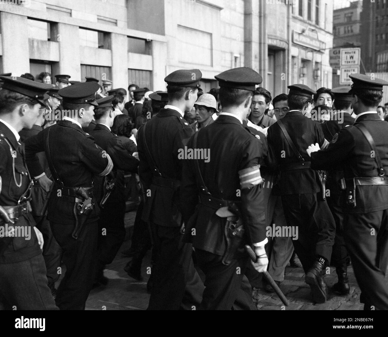Military and Japanese policemen are holding the crowds after they ...