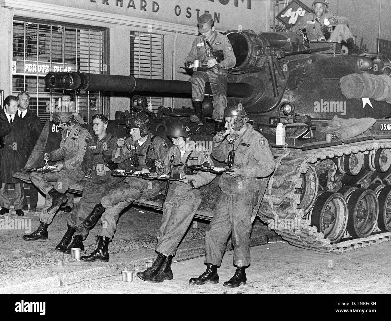 US soldiers sitting on a tank eat their lunch at the Friedrich Strasse ...