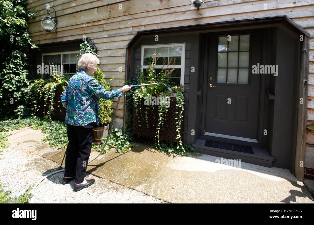 This Wednesday, July 27, 2011 photo shows Jane Merrill as she waters ...