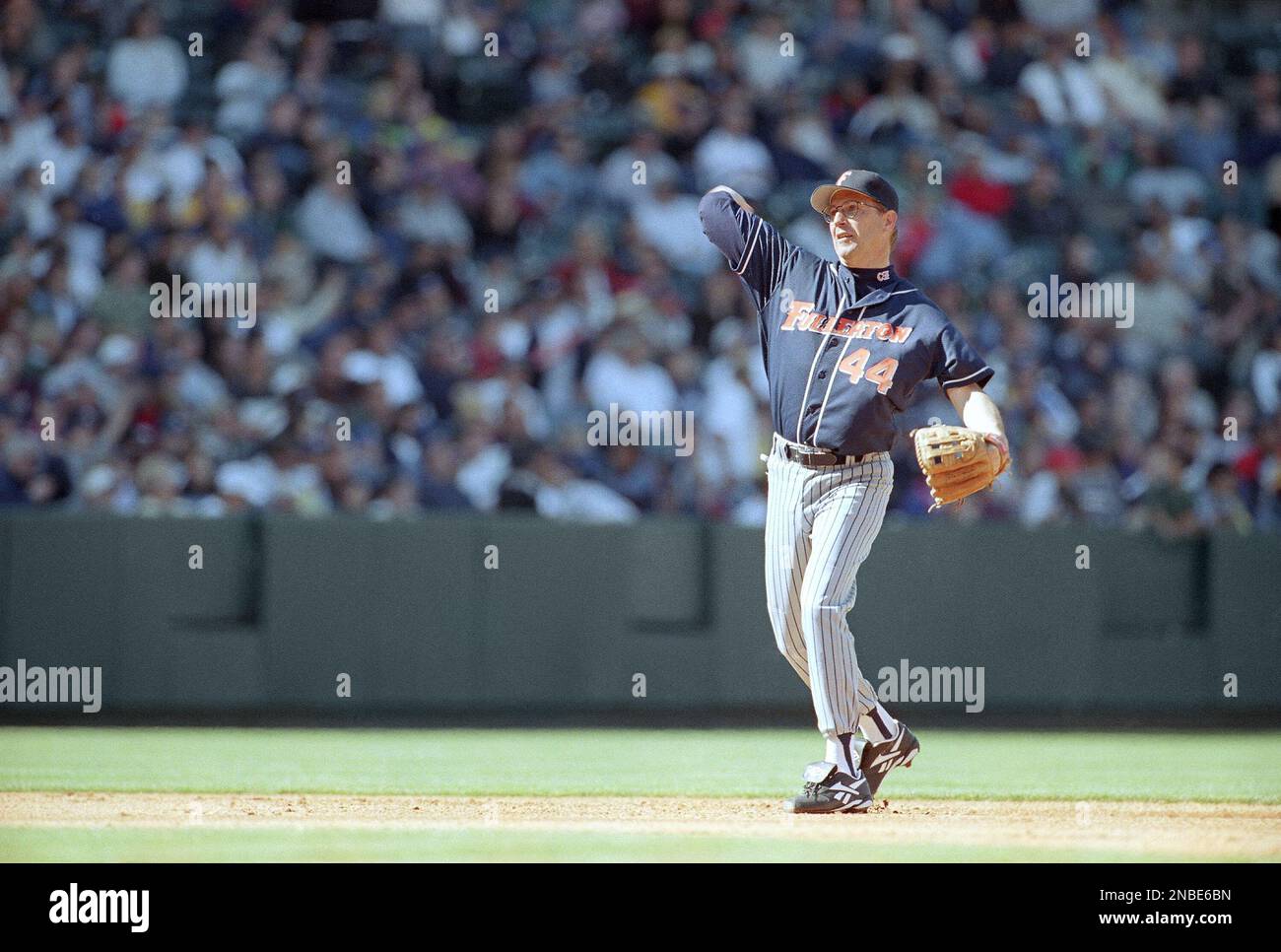 Actor Kevin Costner, playing shortstop for Cal State Fullerton, throws ...