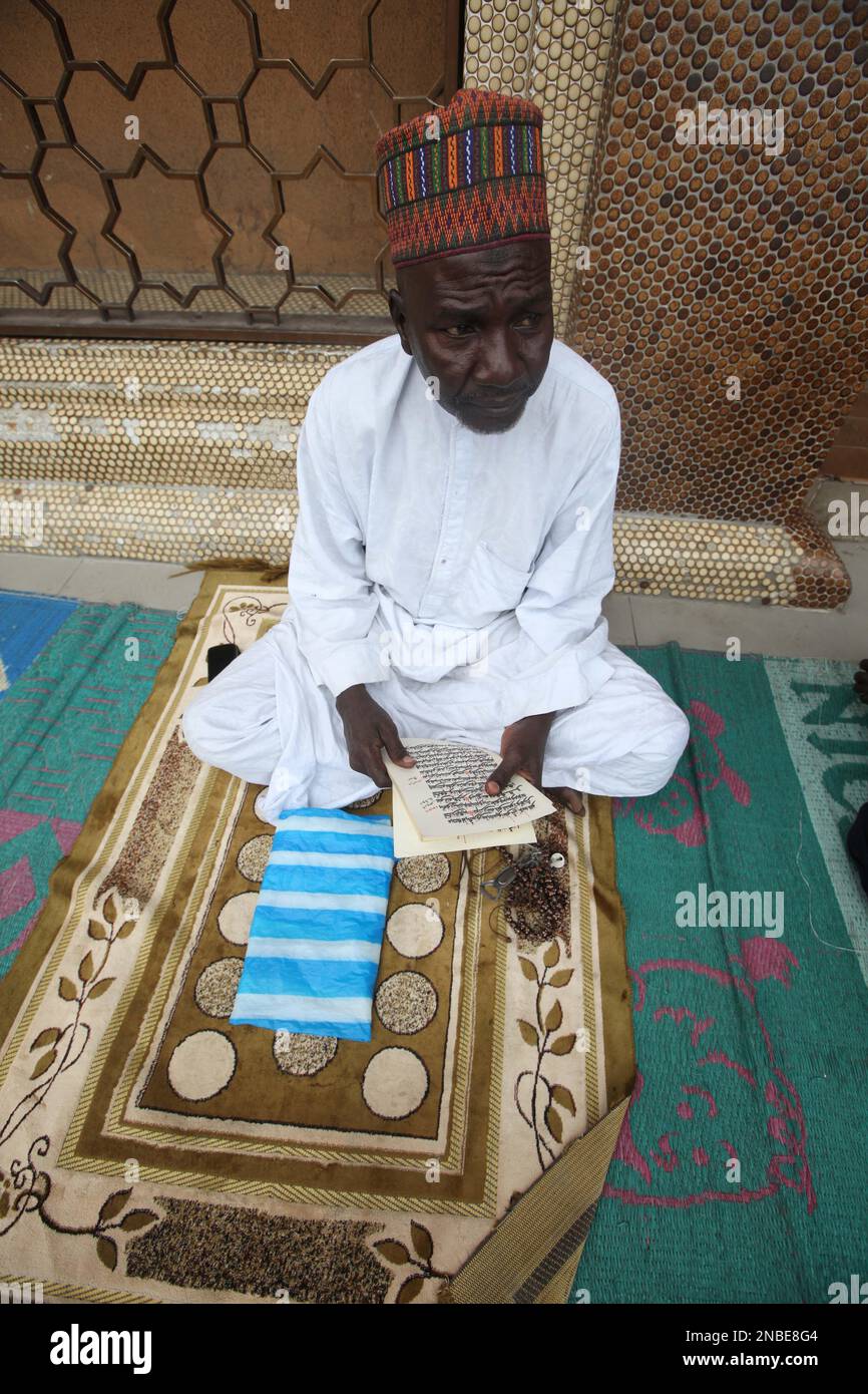 A Nigerian Muslim man reads the Quran, Islam's holy book, on the first ...