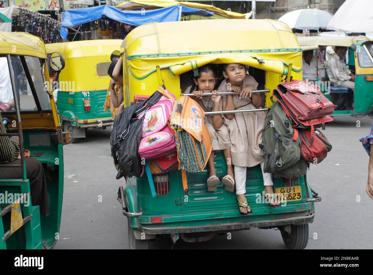 Indian school children are ferried in an overcrowded auto rickshaw, a ...