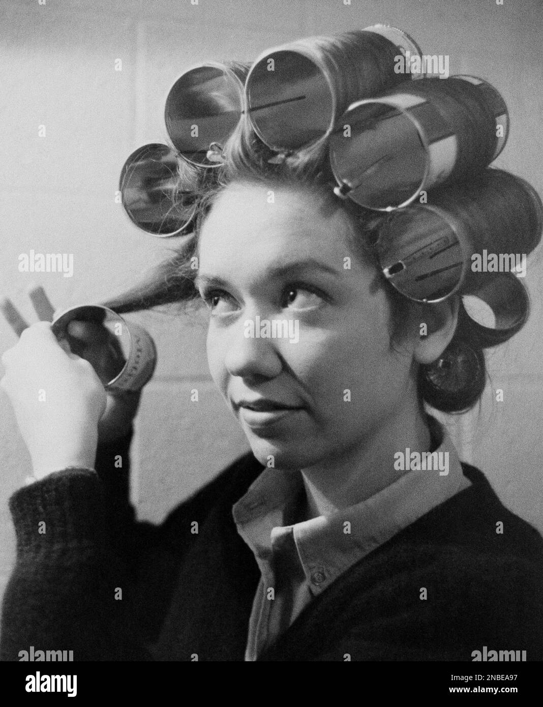 Indiana University Coed Barbara Benhan rolls her hair in empty frozen orange juice can to ...