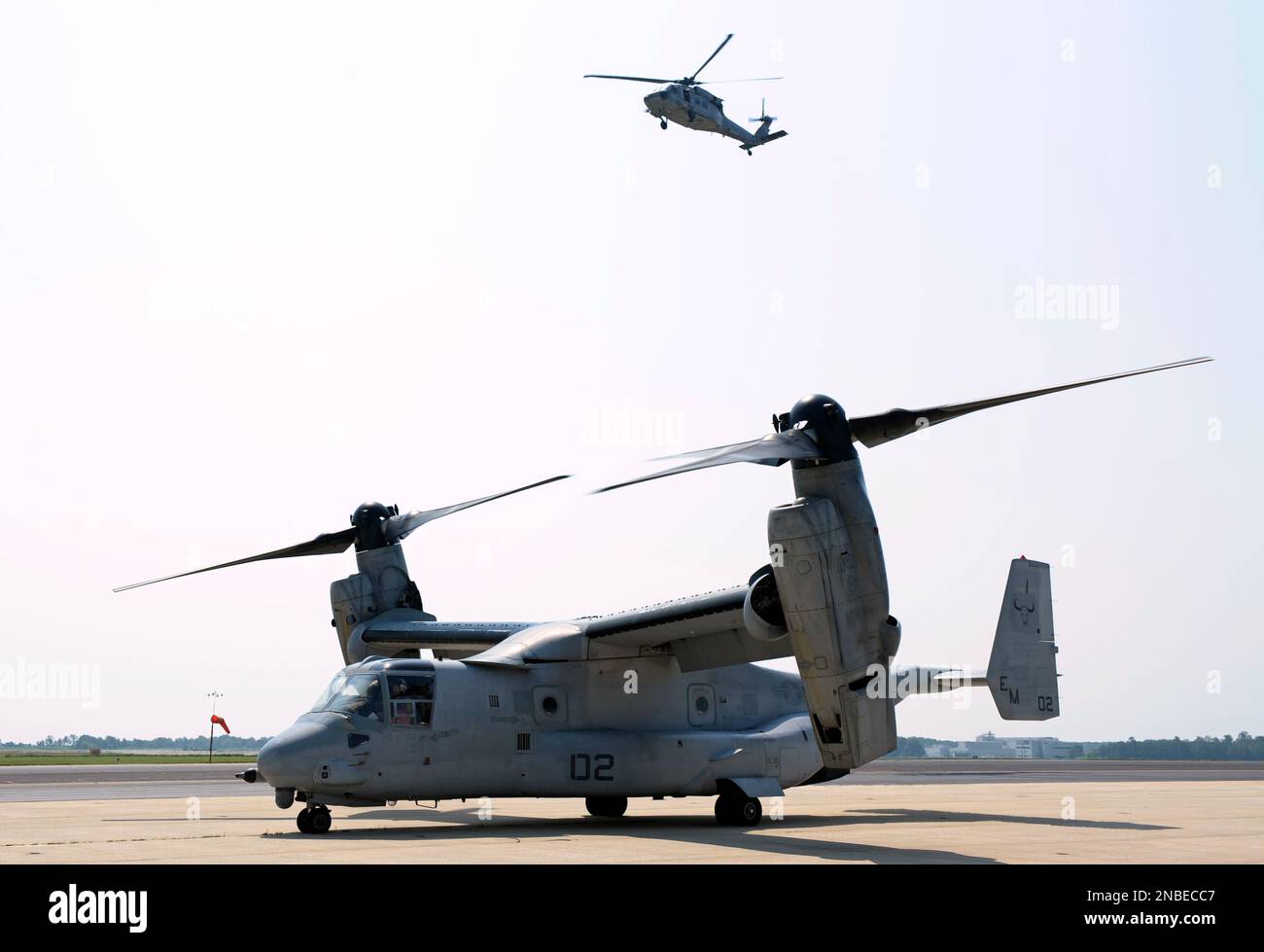 A MH-60 Seahawk helicopter flies over a Marine Corp MV-22 Osprey as it ...
